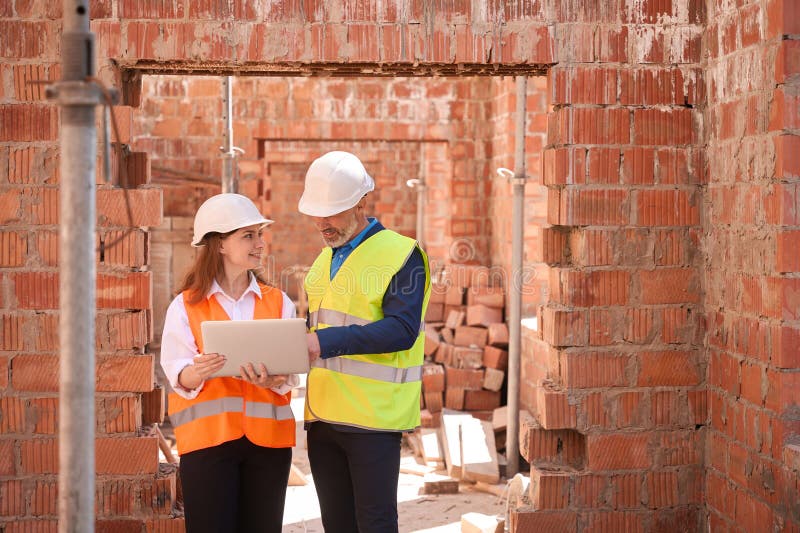 Contractors in Hardhats Checking Building Construction Using Laptop ...