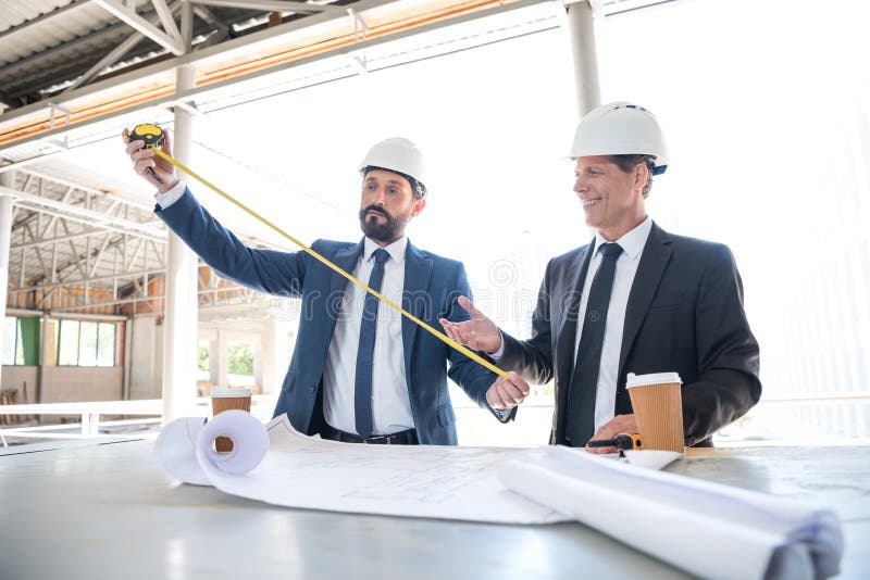 Contractors Talking while Working with Blueprints at Construction Stock ...