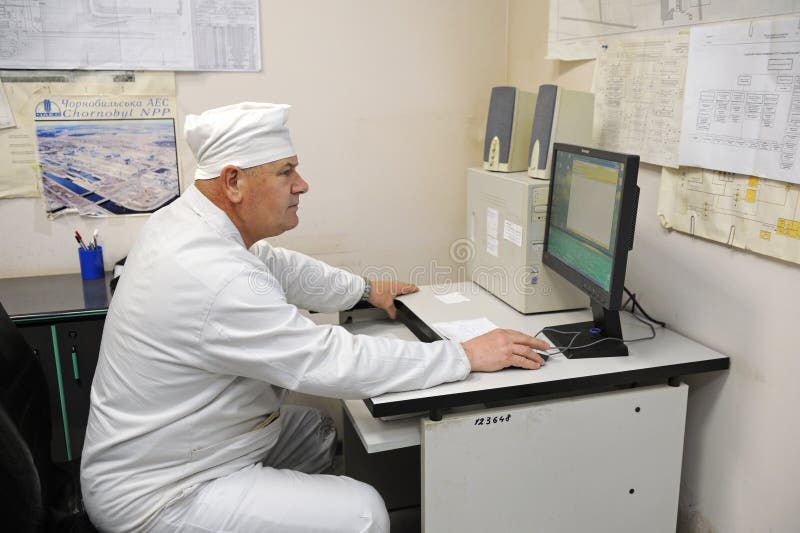 At the Control Operations Room. Operator Sits at the Work Table Looking ...
