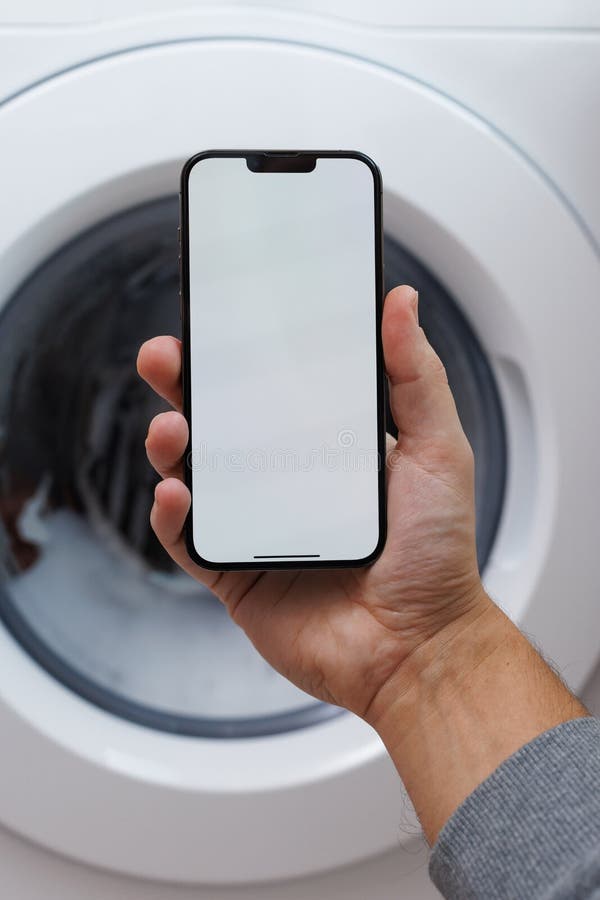 Controlling the Washing Machine with Smartphone App. Close-up of Man ... Controlling the Washing Machine with Smartphone App. Close-up of Man ...