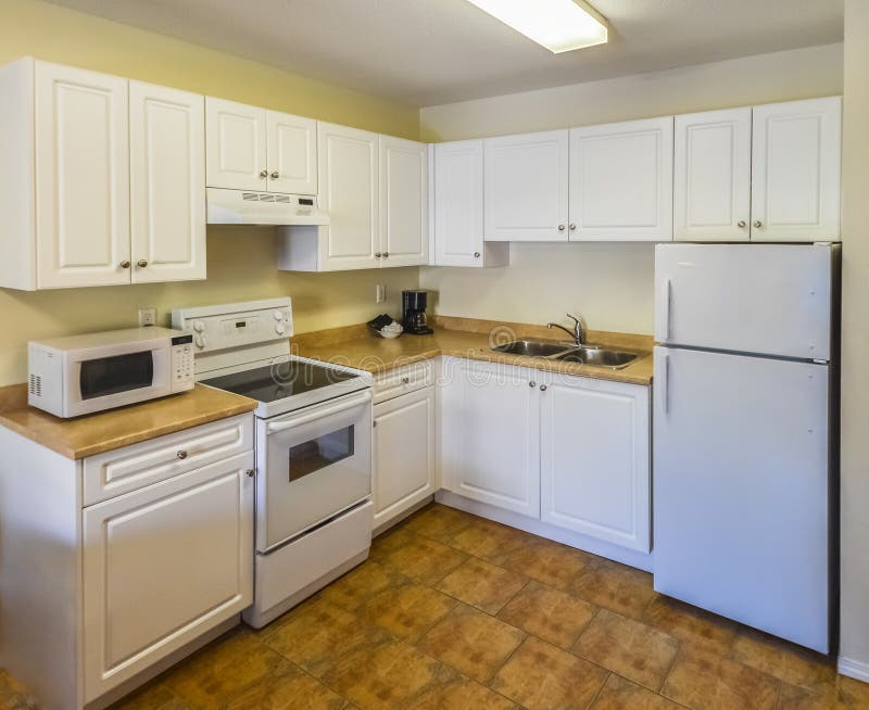 Conventional White Kitchen with the Table and Chairs in Dinner Area ...