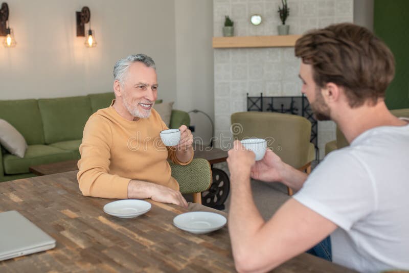 Two Men Sitting at the Table, Having Tea and Talking Stock Photo ...
