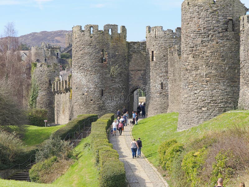 Conwy, Wales. a Group of People are Walking Down a Path in Front of the ...