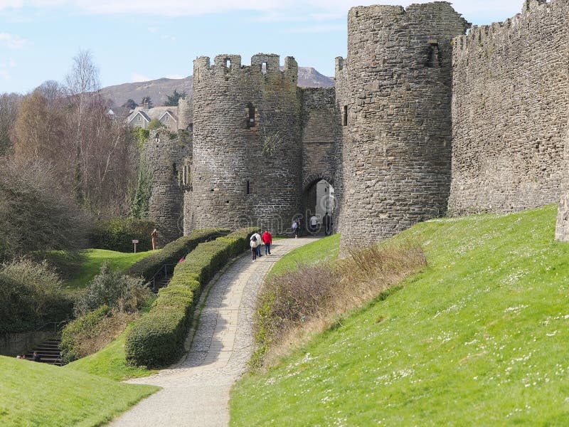 Conwy, Wales. a Group of People are Walking Down a Path in Front of the ...
