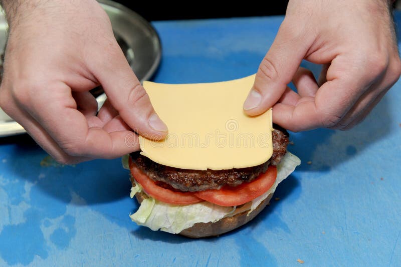 Cook Adding Cheese on Burger. Preparing and Making Hamburger. Stock ...