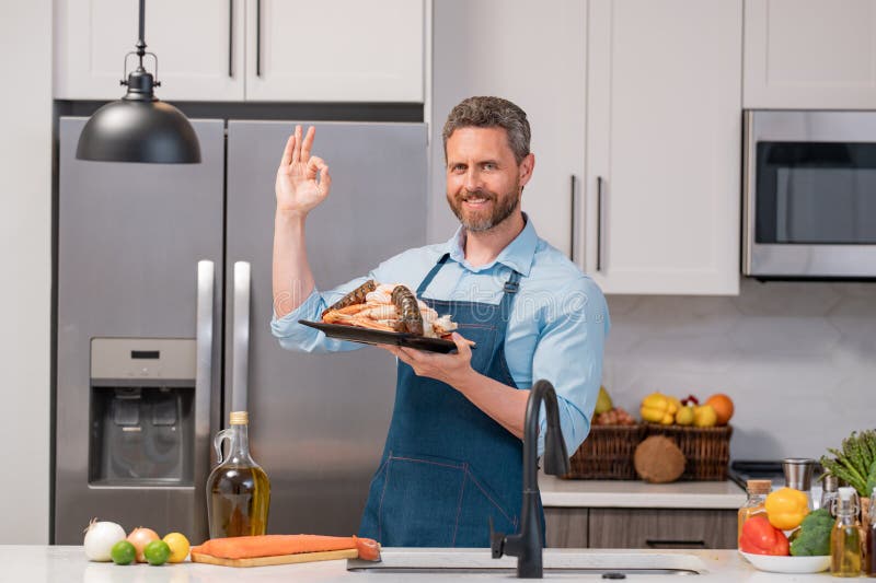 Cook in Chef Apron with Raw Seafood on Kitchen. Chef Man in Uniform ...