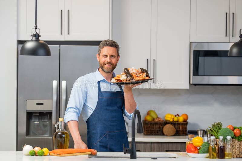 Cook in Chef Apron with Raw Seafood on Kitchen. Chef Man in Uniform ...