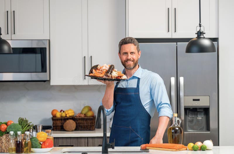 Cook in Chef Apron with Raw Seafood on Kitchen. Chef Man in Uniform ...