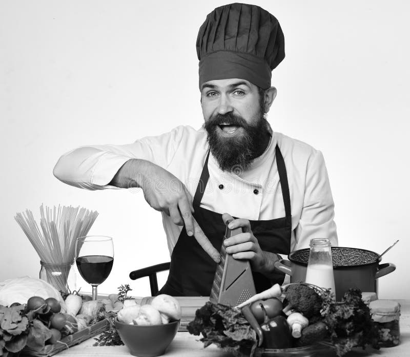 Cook with Curious Face Sits by Kitchen Table with Vegetables Stock ...