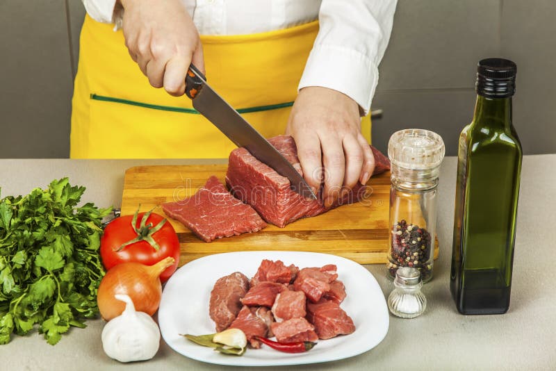 Cook Cuts Meat Fillet on a Table Stock Photo - Image of green, pepper ...