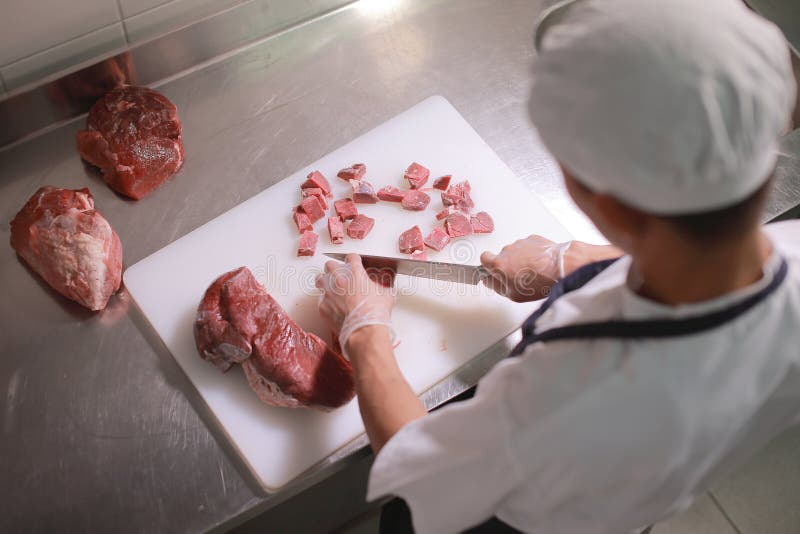 Cook Cuts Raw Meat on the Kitchen Table. Beef Stock Image - Image of ...