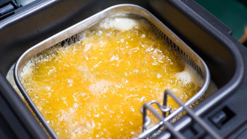 The Cook Fries Meat in a Deep Fryer. Preparation in a Deep Fryer Stock ...
