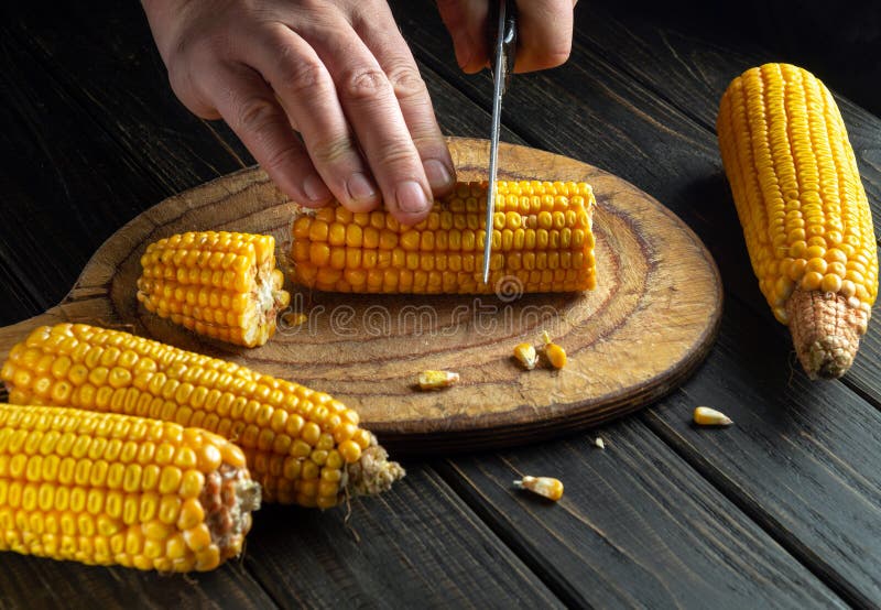 Cook Hands with a Knife Cut Corn Kernels on a Cutting Kitchen Board ...