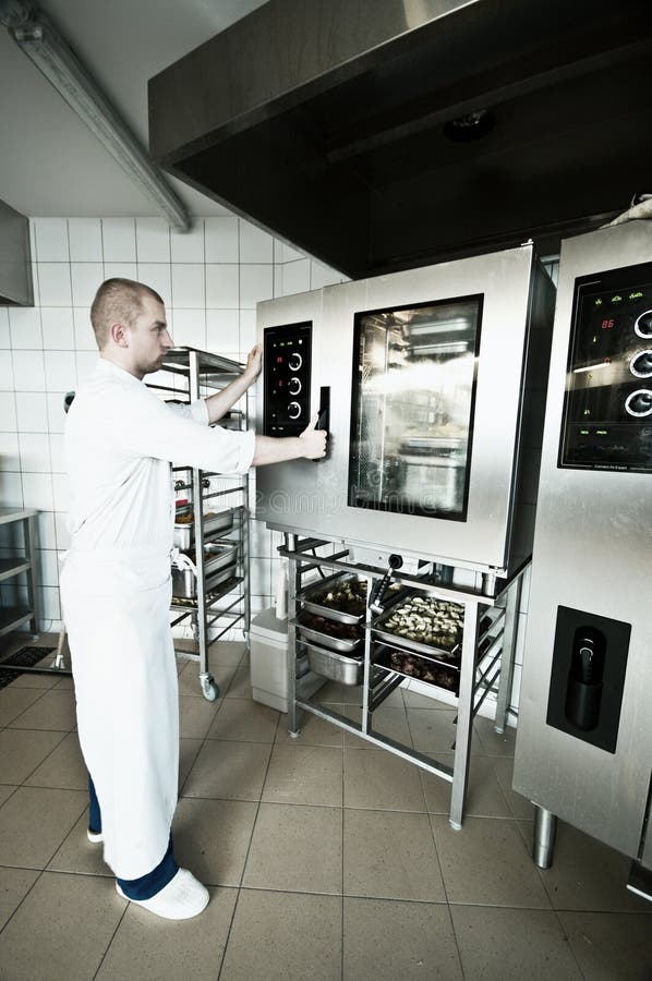 Cook in industrial kitchen stock photo. Image of interior - 34864862
