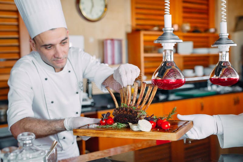 The Cook Passes the Waiter the Finished Dish. Rack of Lamb. Stock Photo ...