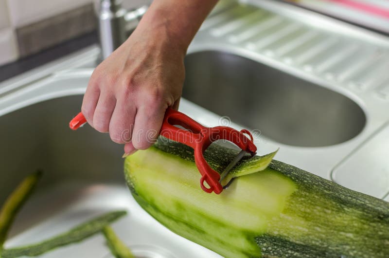 The Cook Peels a Large Zucchini with a Knife from the Peel Stock Photo ...