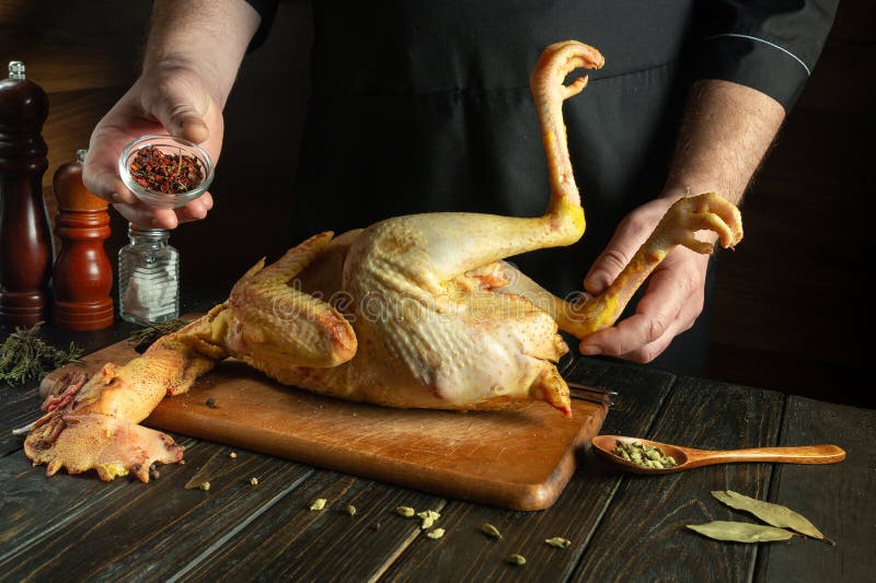 The Cook is Preparing a Raw Rooster on the Kitchen Table. Adding Dry ...