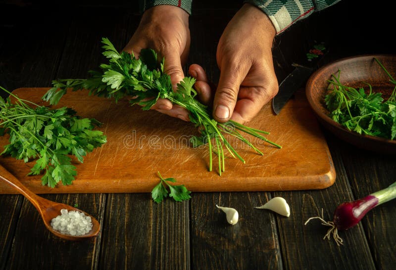 The Cook is Preparing a Salad of Parsley and Fresh Vegetables on the ...