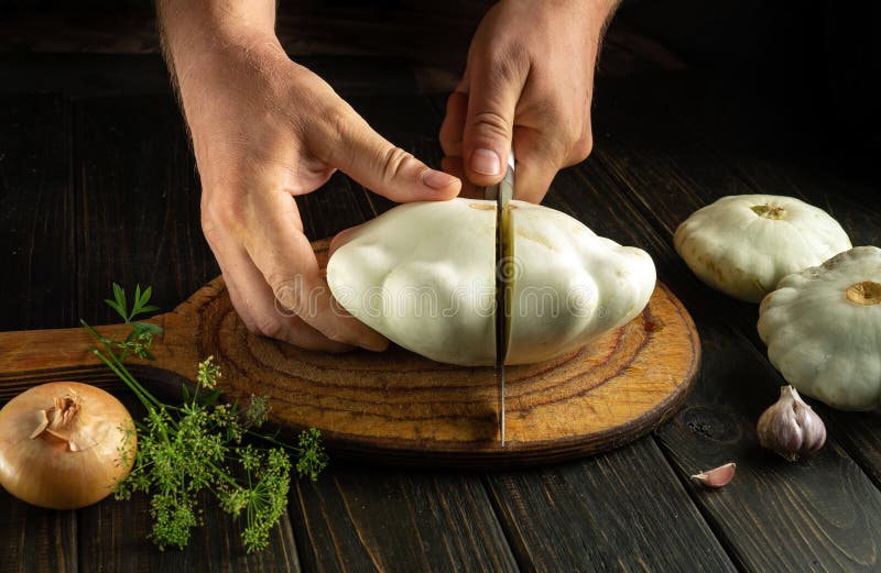 The Cook with a Knife Cuts Fresh Wheat Bread on a Kitchen Cutting Board ...