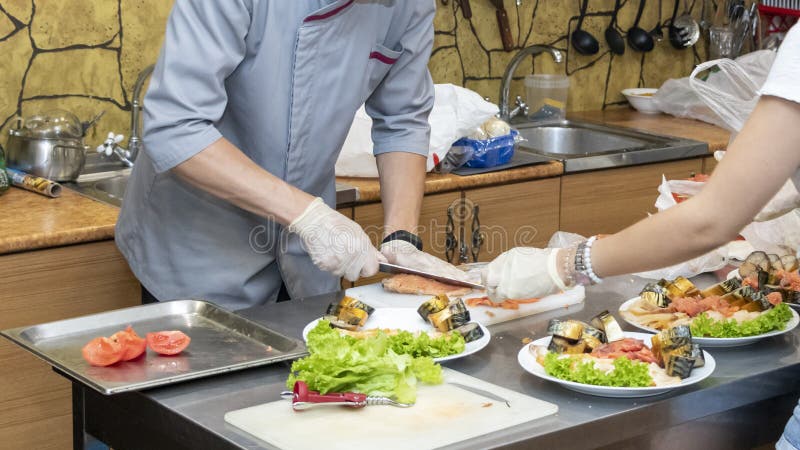 A Cook Serves Fish Dishes in the Kitchen Stock Image - Image of ...