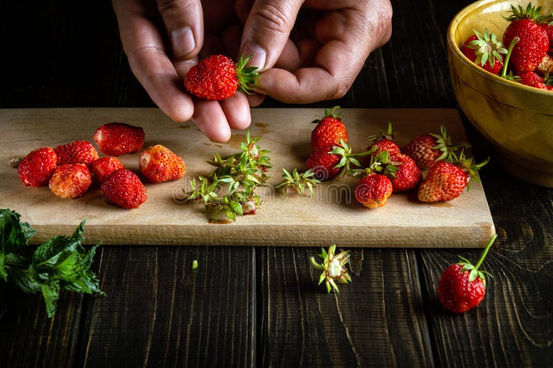 The Cook Sorting through Fresh Strawberries on the Cutting Board of the ...