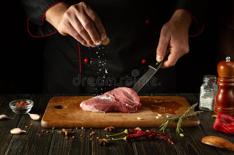 The Cook Sprinkles Salt on the Raw Meat. Preparing Beef Steak before ...