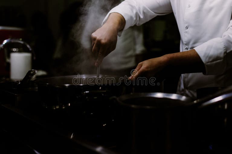A Cook Stirring Pots in the Kitchen. Big Pots in the Kitchen. Blurry ...