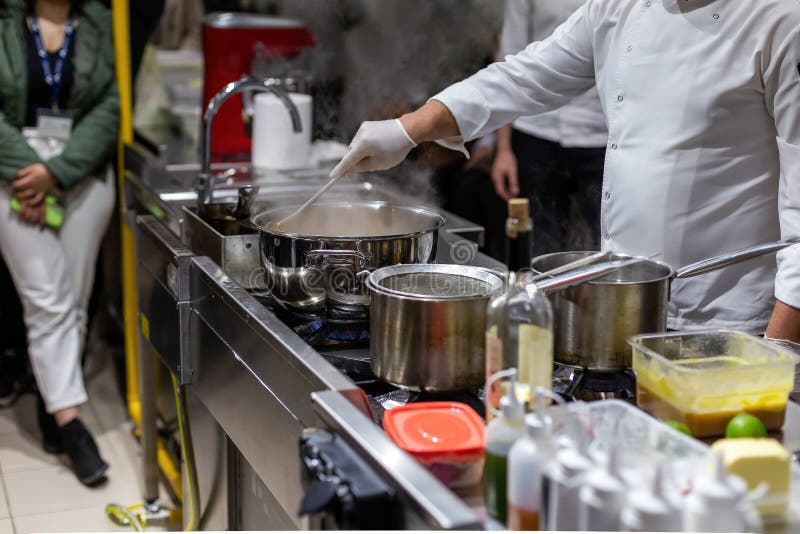A Cook Stirring Pots in the Kitchen. Big Pots in the Kitchen Stock ...