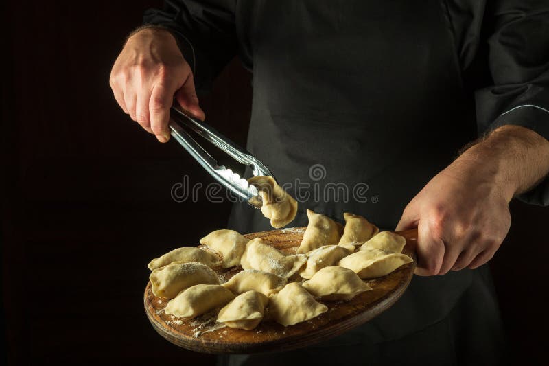 The Cook Takes and Flips the Raw Dumpling with a Culinary Tool. Stock ...