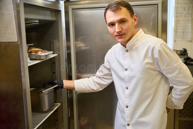 Cook in Uniform Puts a Container of Food in Refrigerator Stock Photo ...