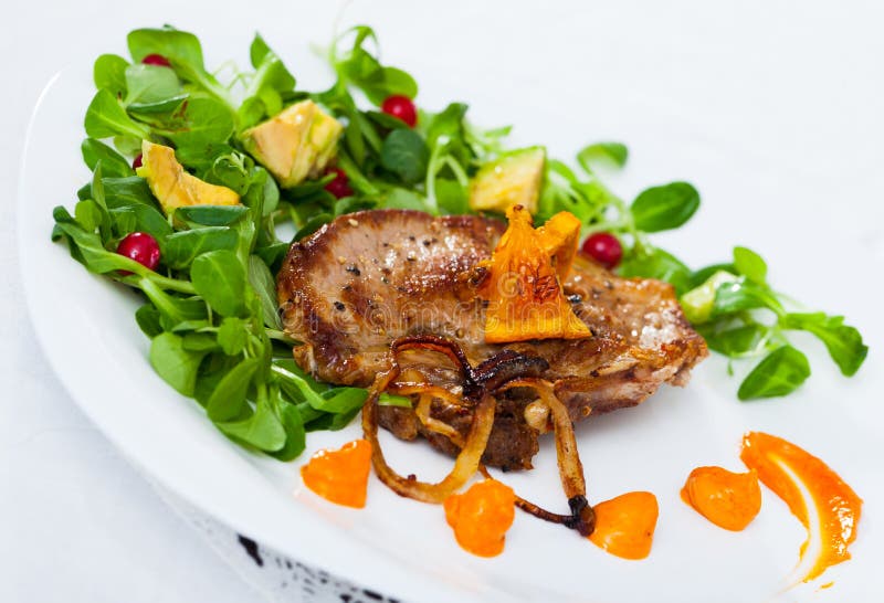 Cooked Fried Pork Meat with Herbs, Sauce and Berries on Plate Stock ...