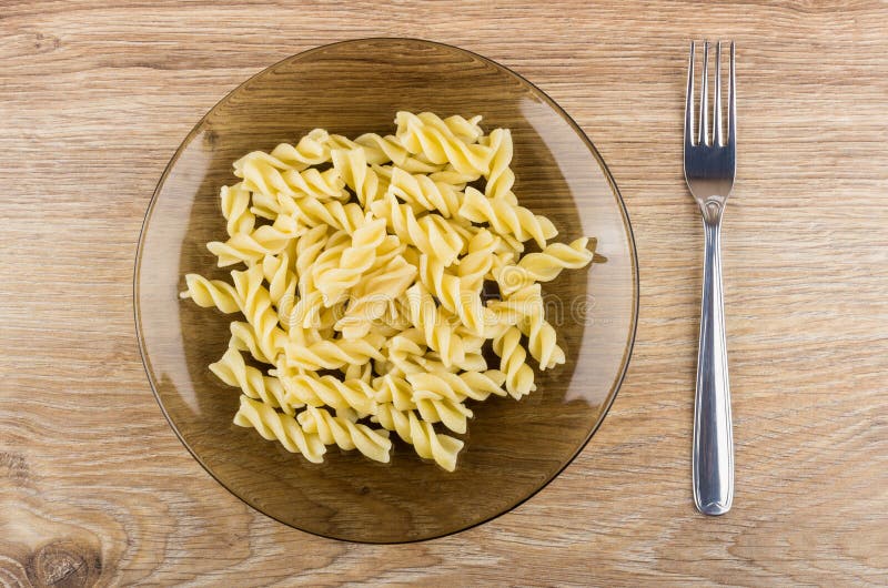 Cooked Pasta Fusilli in Brown Plate and Fork on Table Stock Photo ...
