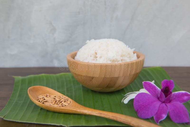 Cooked Rice in Bowl on Green Banana Leaf and Paddy in Spoon and Orchid ...