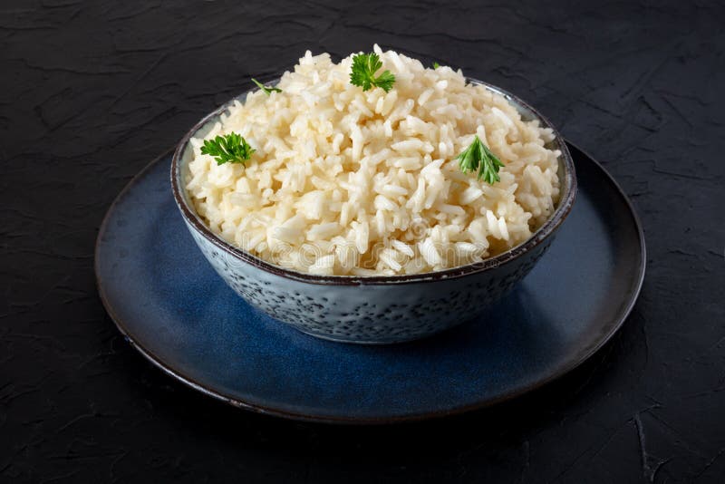Cooked Rice with Fresh Parsley Leaves, in a Bowl, on a Dark Background ...