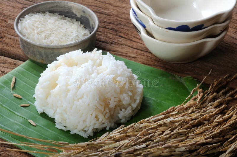 Cooked Rice, Uncooked Rice And Paddy Rice On Wooden Table Stock Photo ...