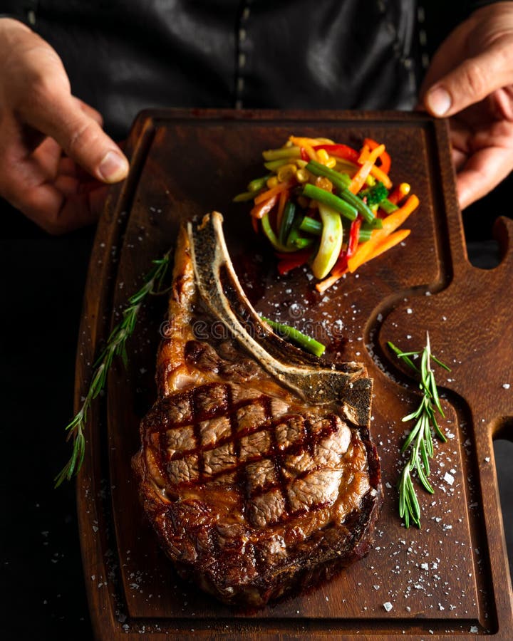 Cooked Tomahawk Long Bone Ribeye Steak on a Serving Board Stock Photo ...