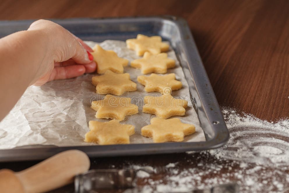 Cookie Cutters and Shortbread Shapes on a Board and a Baking Tray Stock ...