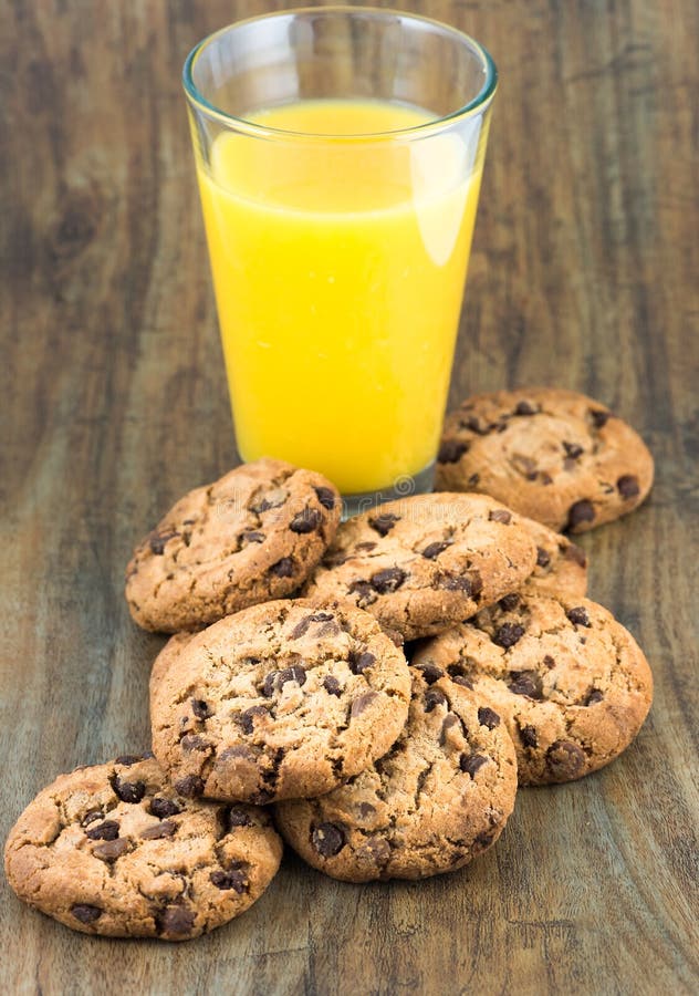Cookies Dos Pedaços De Chocolate E Vidro Do Suco De Laranja Foto de ...