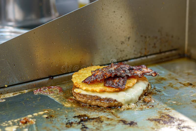 Cooking a Bacon Burger and Cutlet with Salad and Cheese in a Restaurant ...