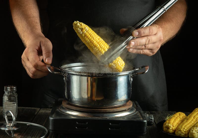 Cooking Boiled Corn in a Pot for Dinner. Chef Holding Tongs with a Head ...