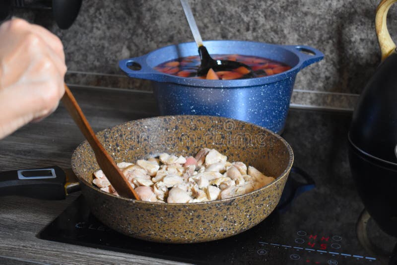 Cooking Delicious Meat in a Skillet on the Stove in Kitchen Stock Image ...