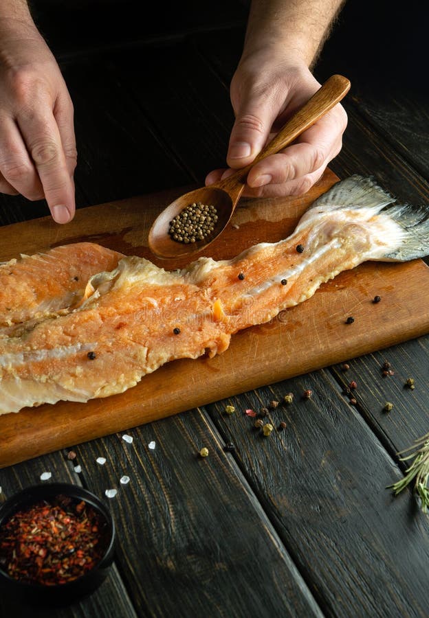 Cooking Fish on the Kitchen Table by the Hands of a Chef. Spoon with ...