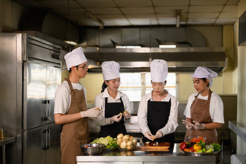 Cooking Instructor Guiding Students in Vegetable Preparation during ...
