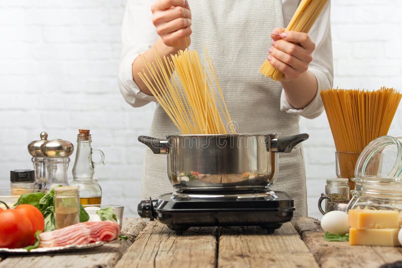 Cooking Italian Pasta, Spaghetti in the Kitchen. in a Light Kitchen ...