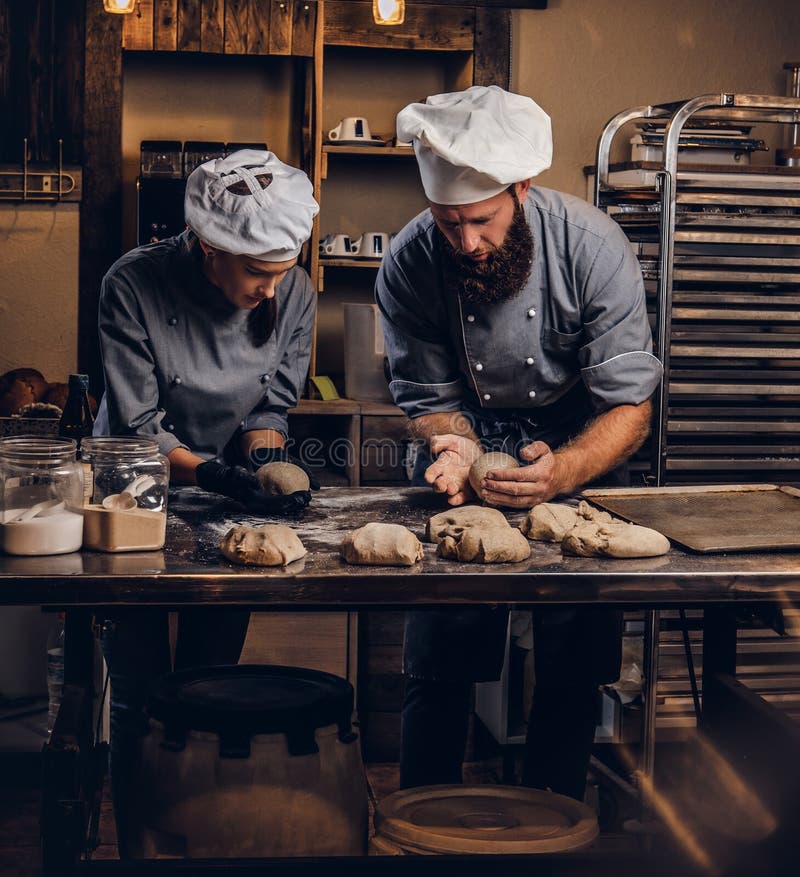 Chef Teaching His Assistant To Bake the Bread in a Bakery. Stock Image ...