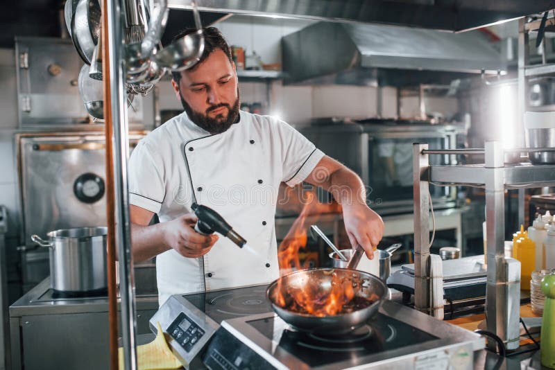Cooking Meal by Using Flames. Professional Chef Preparing Food in the ...