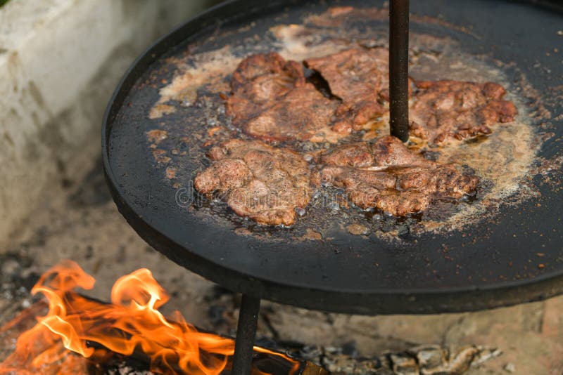 Cooking Pork Meat Over the Fire by the Jar on a Disk Stock Image ...