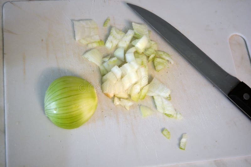 A Large White Green Onion and a Utility Knife with a Black Handle Lie ...