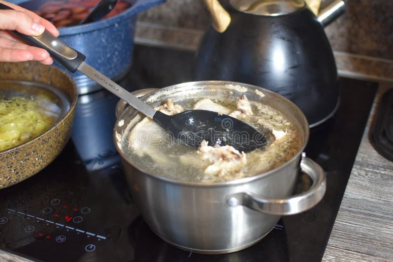 Cooking Soup in a Saucepan on the Stove in Kitchen. Skim the Broth ...