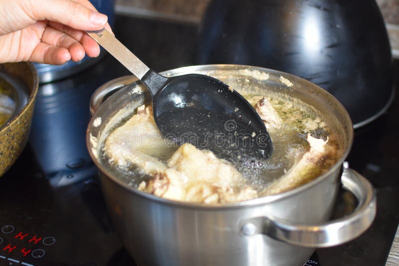 Cooking Soup in a Saucepan on the Stove in Kitchen. Skim the Broth ...